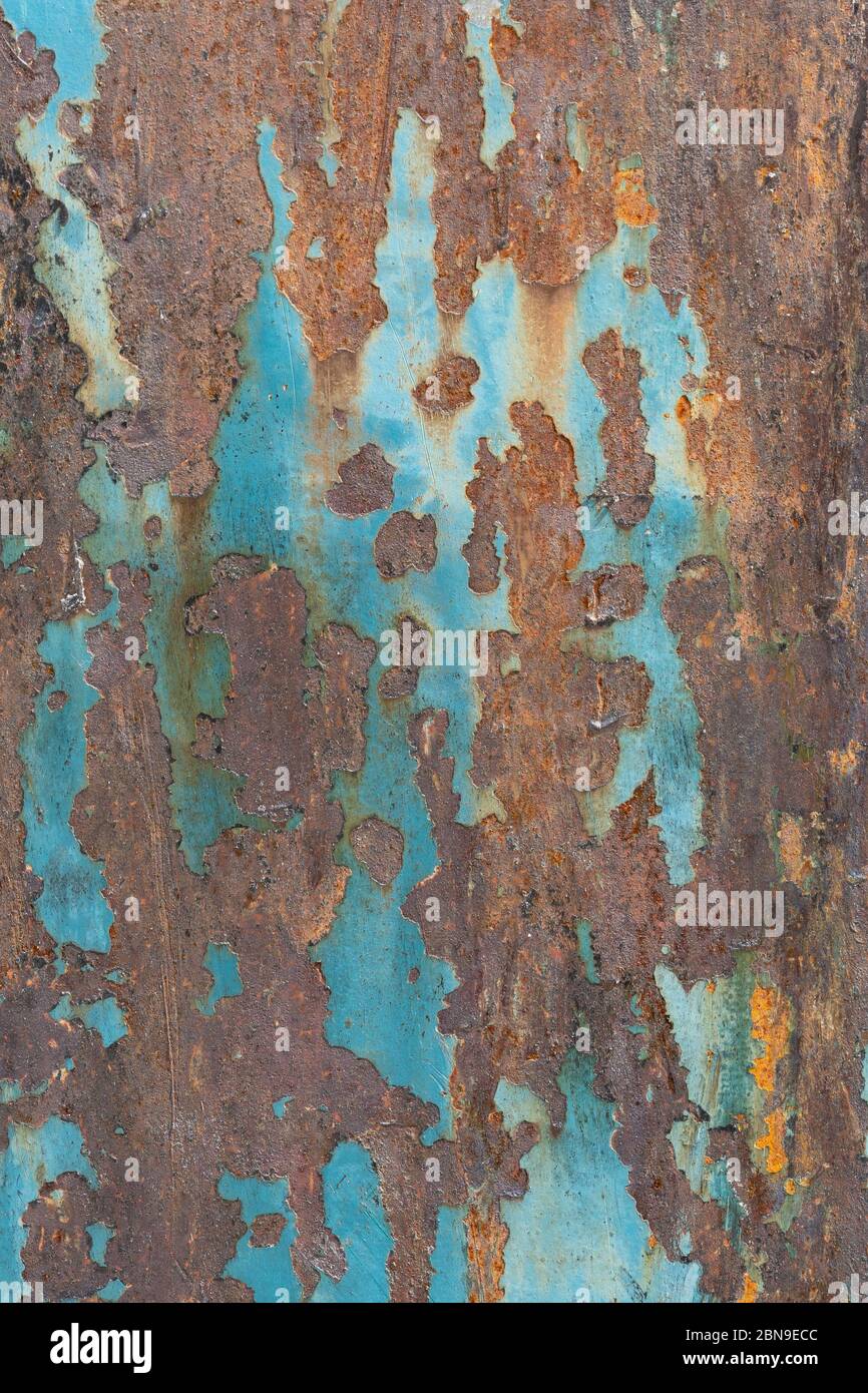 background of blue painted metal that is peeling away to expose the ...