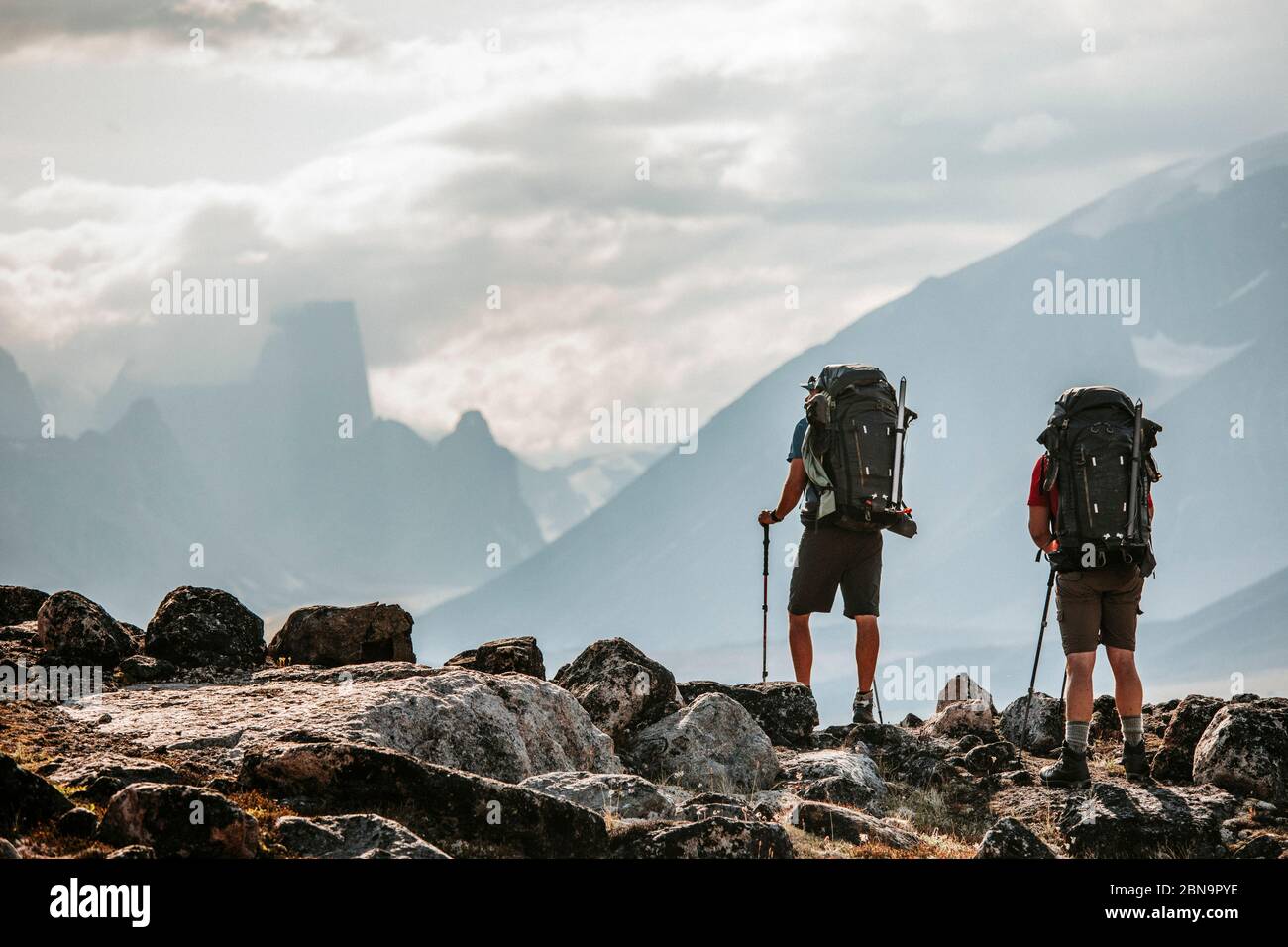 Rear view of two backpackers hiking through Akshayak Pass Stock Photo ...