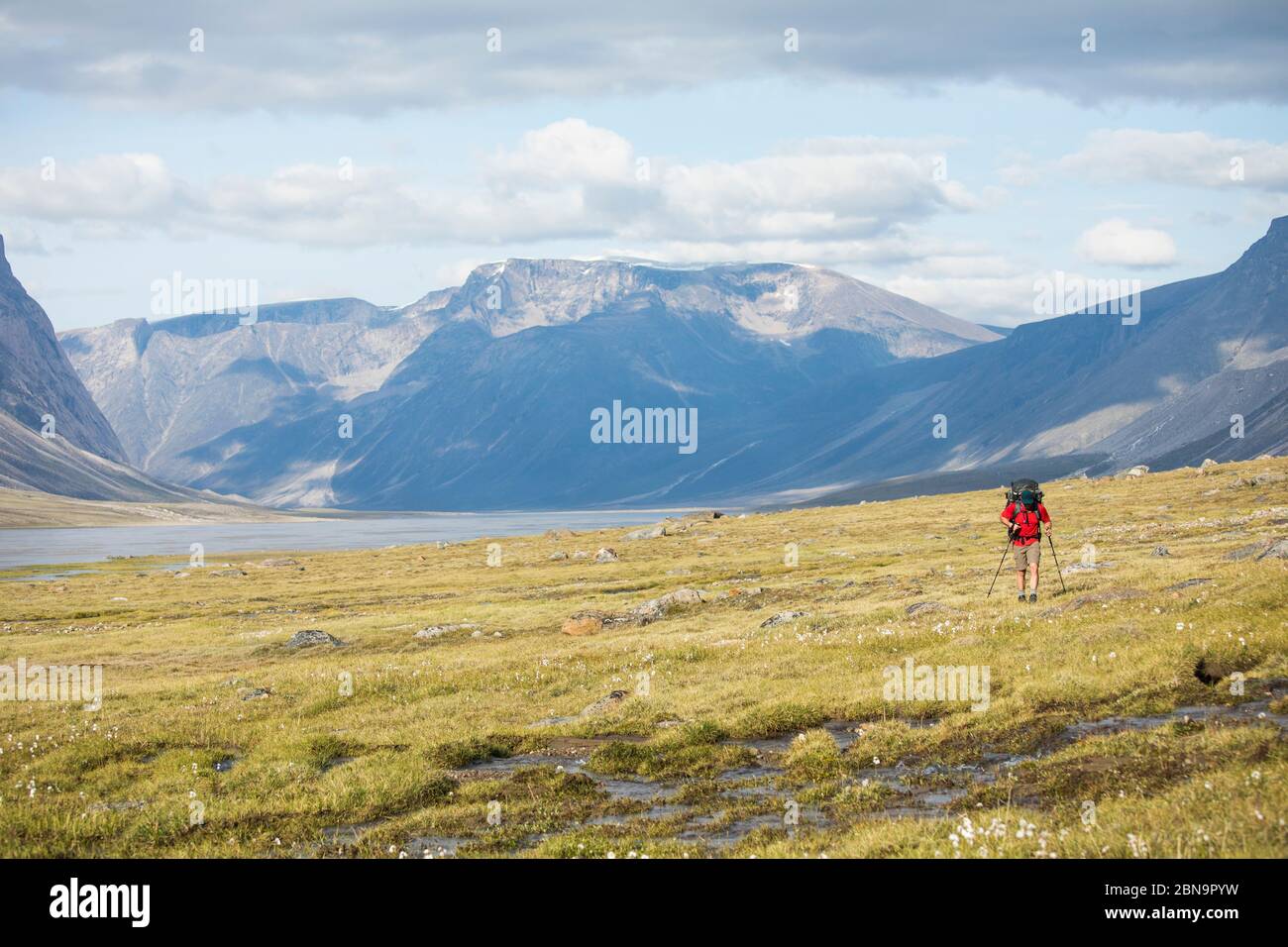 Backpacker hiking through open landscape Stock Photo - Alamy