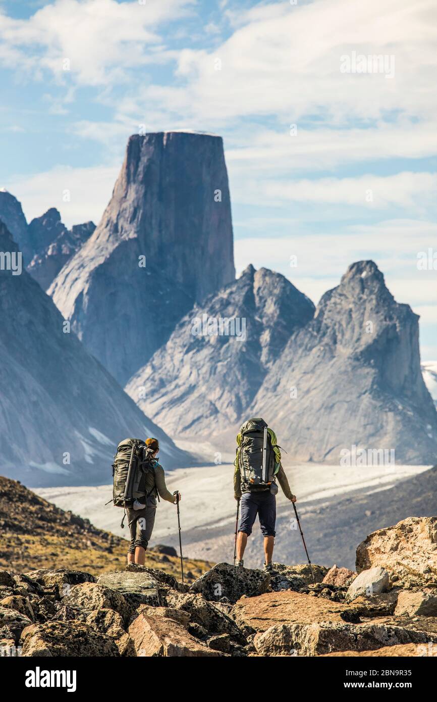 Two climbers enjoy views of Mount Asgard during their approach Stock ...