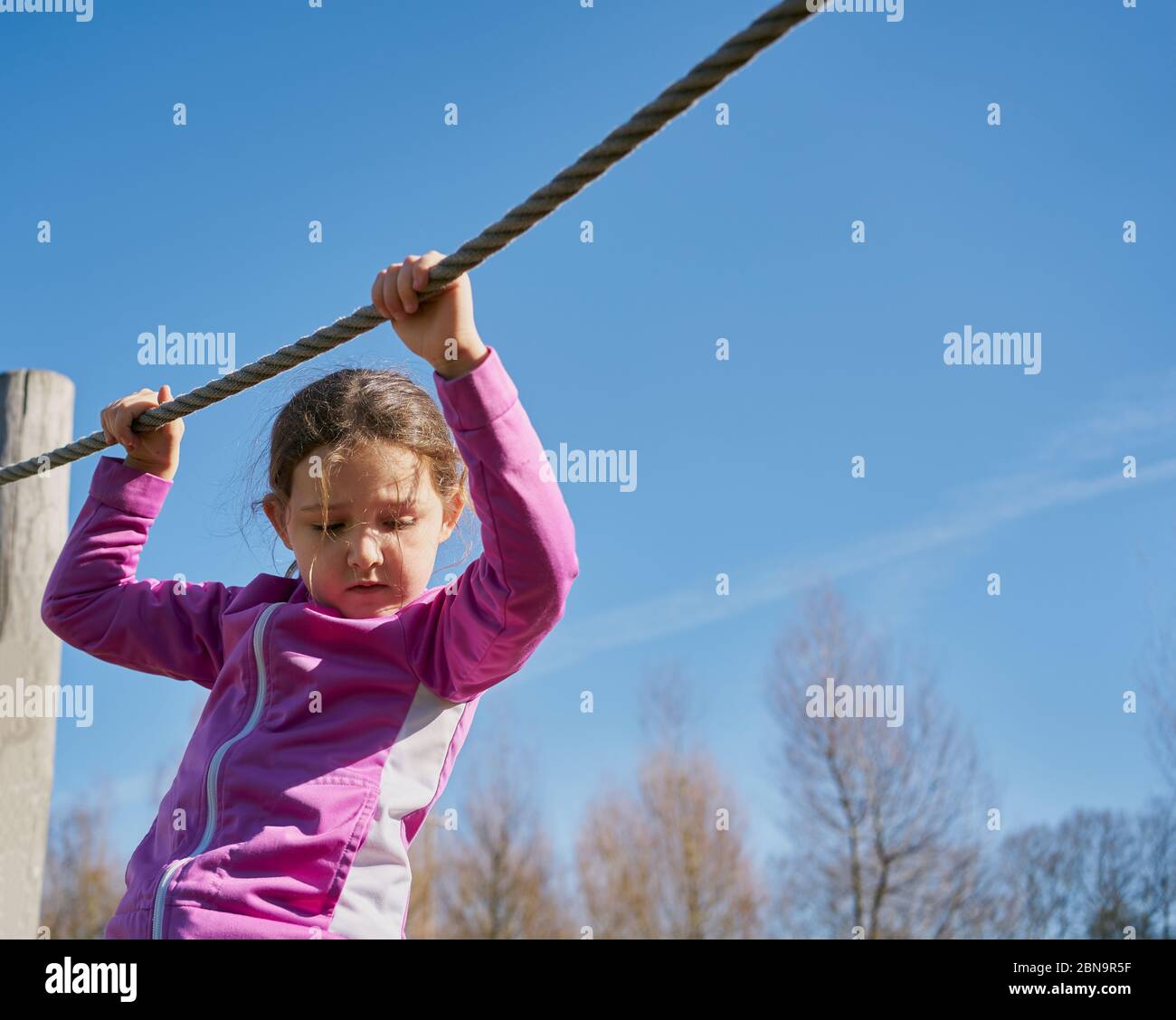 Girl on ropes and zip lines looks Stock Photo - Alamy