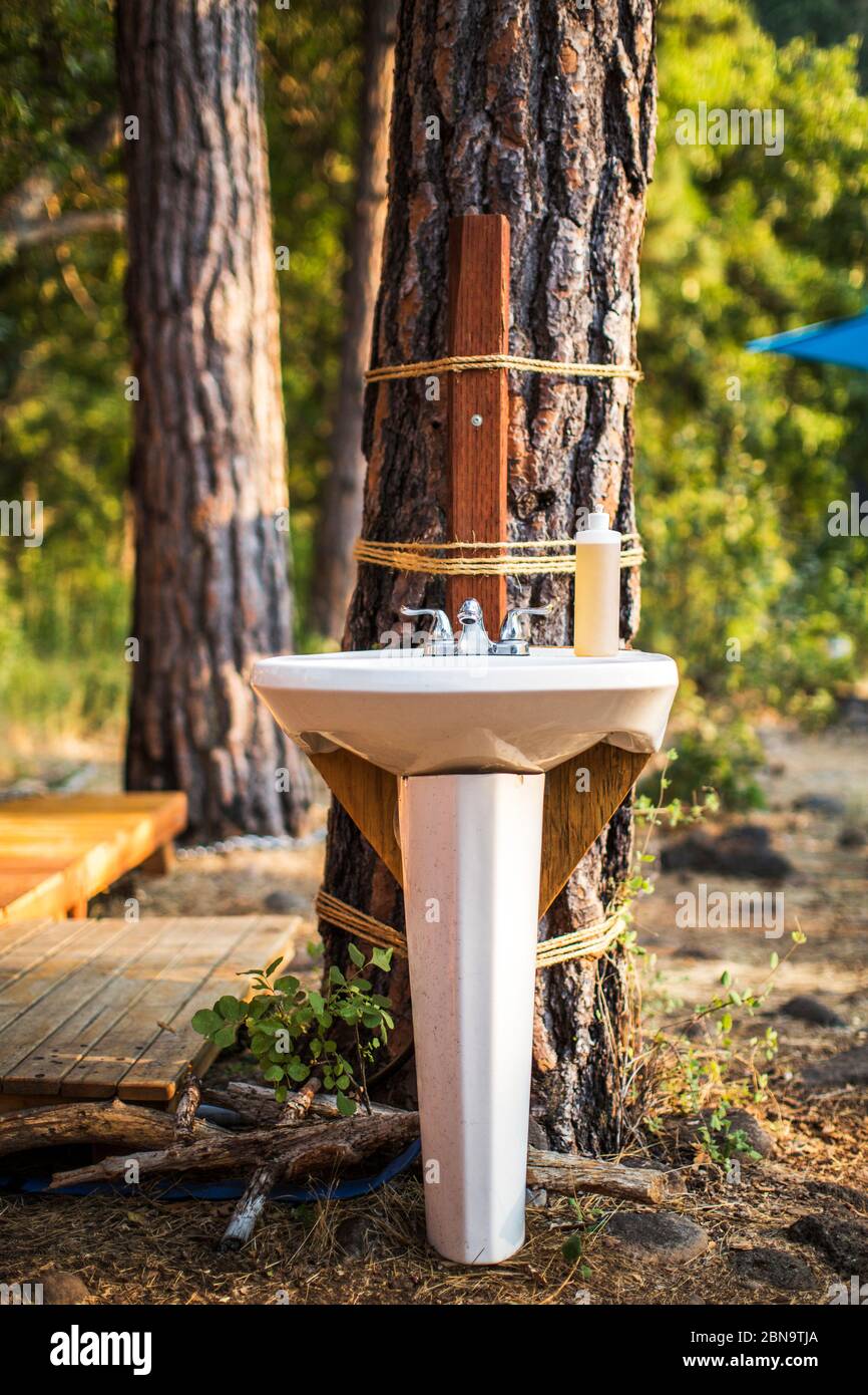 A functioning sink strapped to a tree in a glamping camp Stock Photo ...