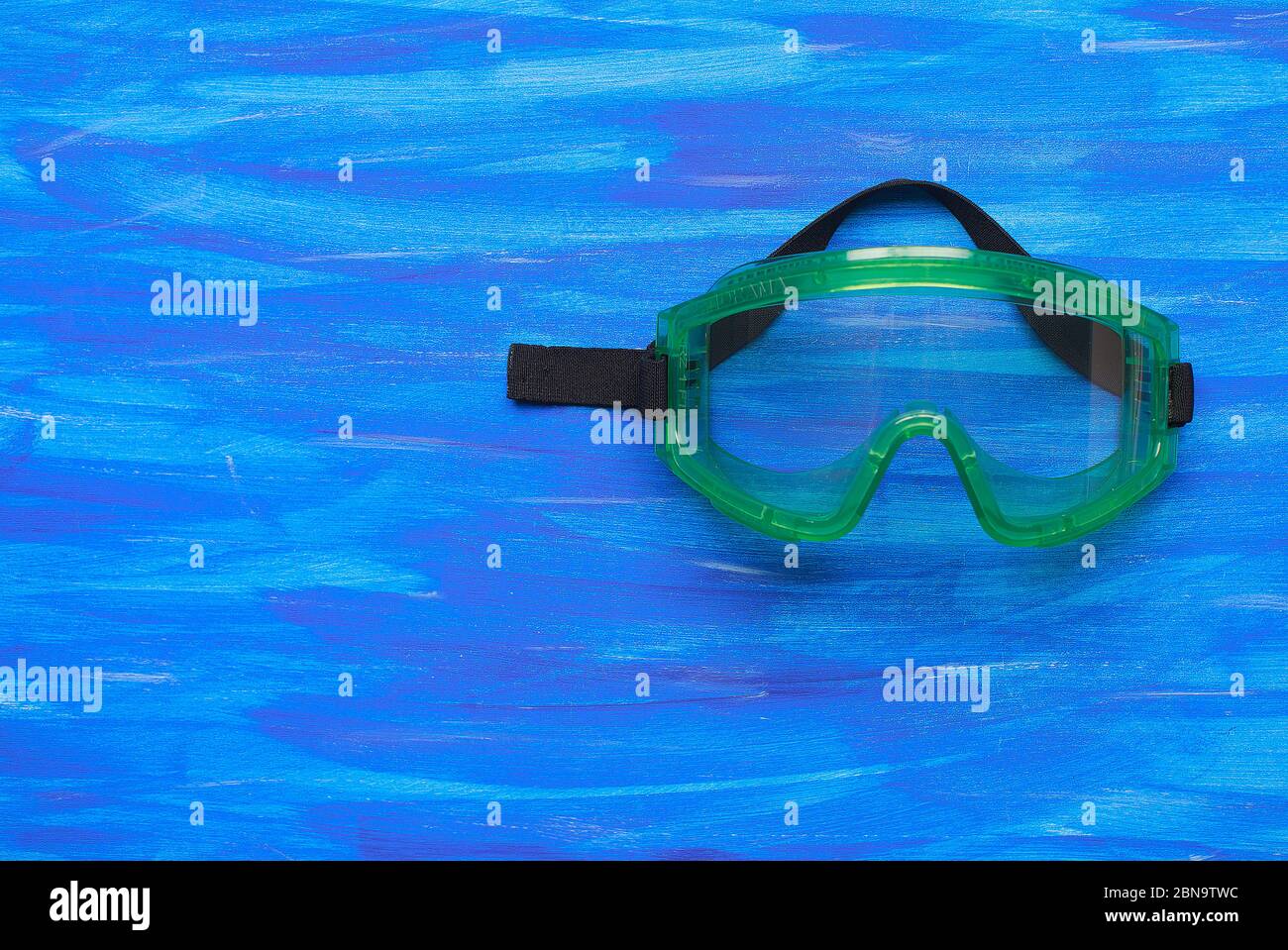 Plastic safety goggles on blue background Stock Photo - Alamy