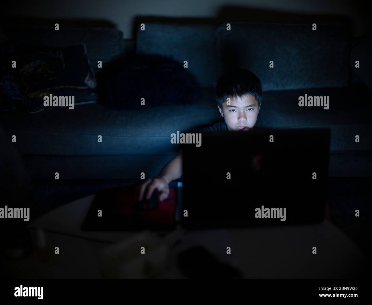 A 12 year-old boy uses computer in dark room Stock Photo - Alamy