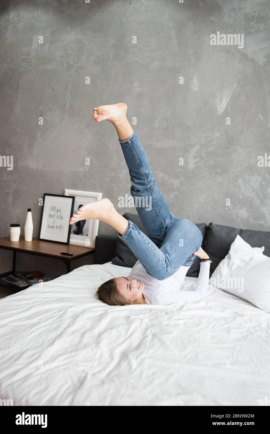 Funny lauhging woman does somersault in bed. Stress free at home Stock ...