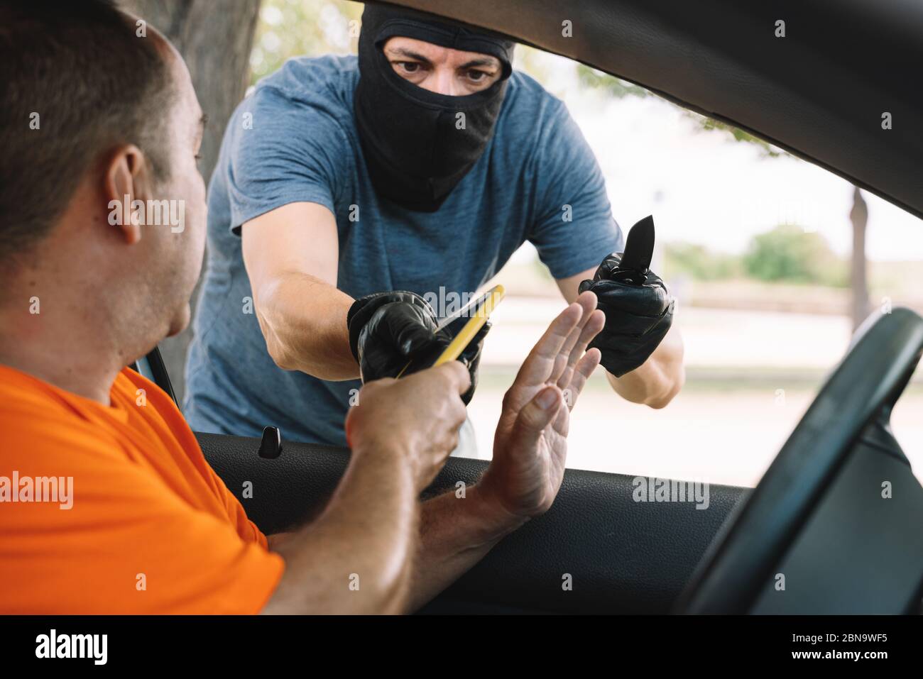 Robber stealing a cellphone with his knife Stock Photo - Alamy