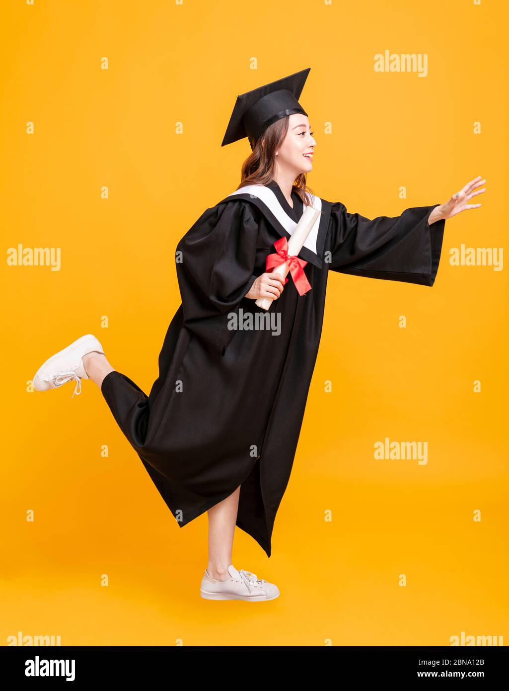 happy young woman in graduation gowns and running Stock Photo - Alamy