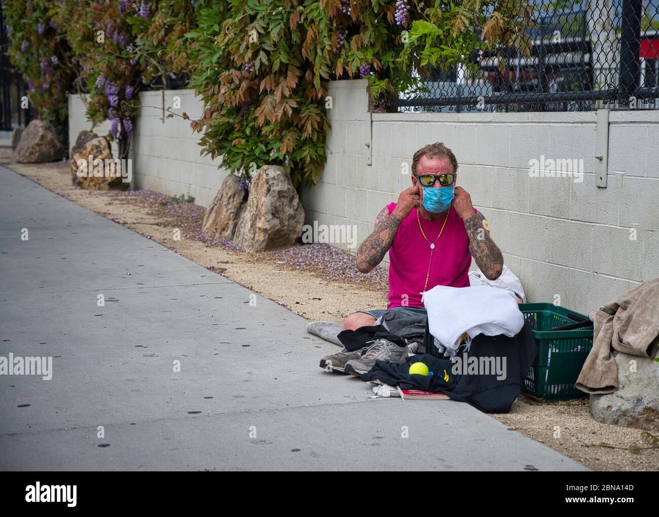 LOS ANGELES, UNITED STATES - Apr 05, 2020: A homeless man puts on his ...