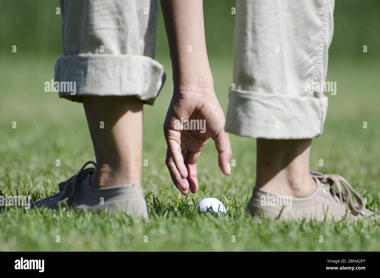 Closeup picture of a human taking a white gold ball in the field Stock ...