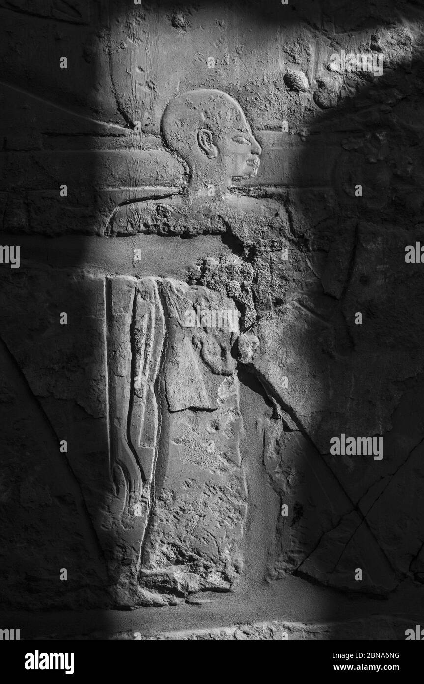 Vertical grayscale shot of an engraved figure of a male figure on the ...