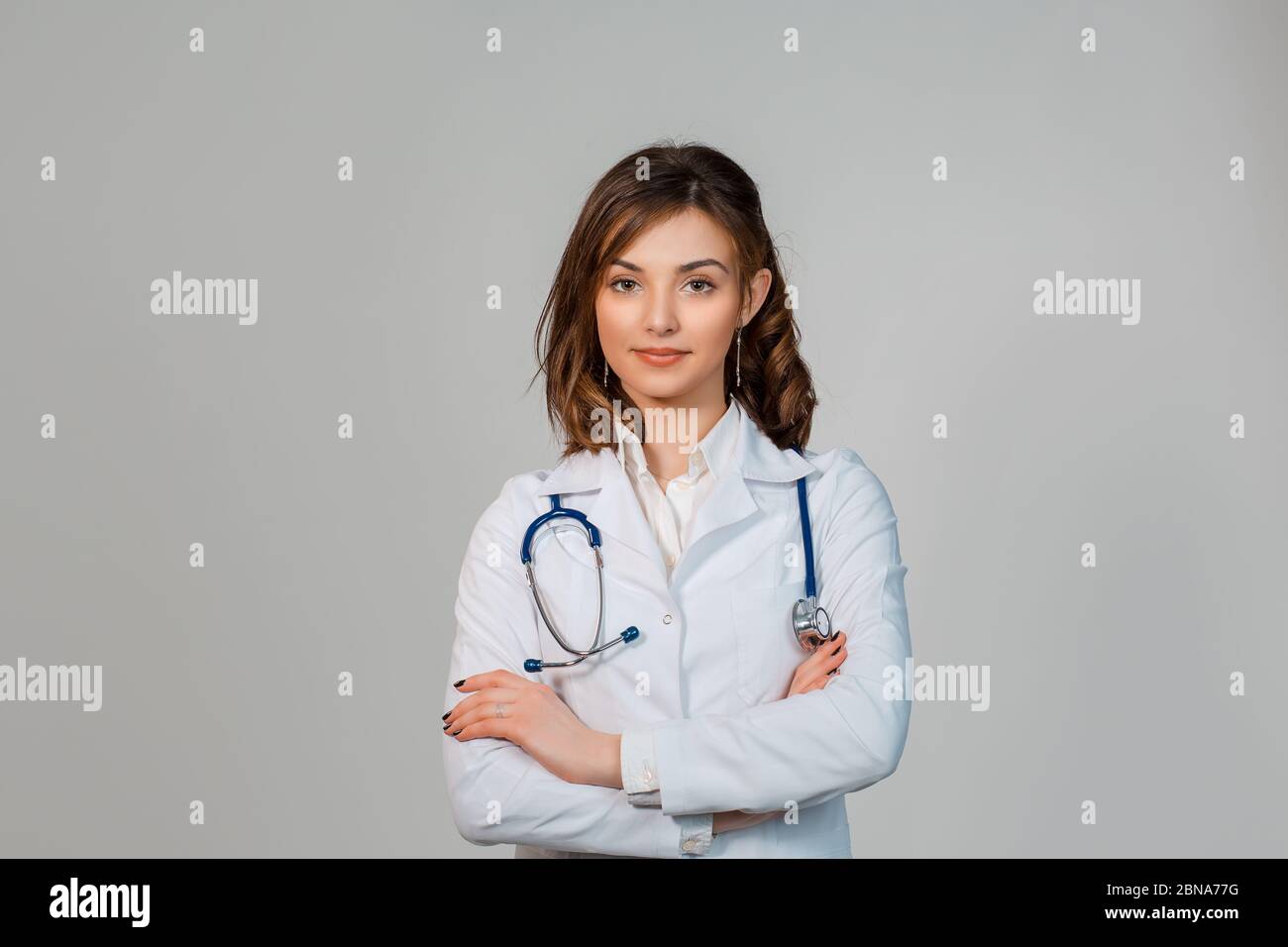 Woman in white doctor robe with stethoscope arms crossed isolated on ...