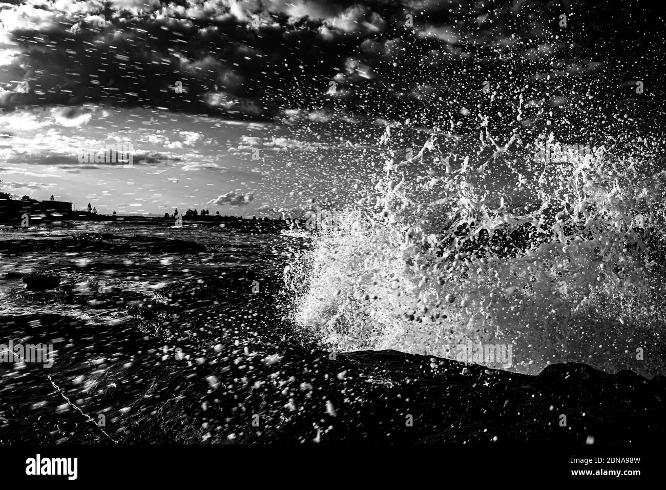 Beautiful greyscale shot of a seashore with the sea on the background ...