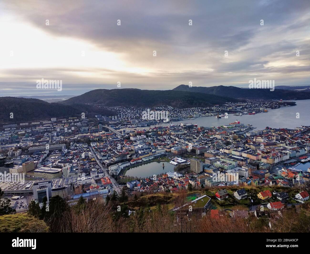 Aerial shot of the peninsula city in Bergen, Norway under a cloudy sky ...