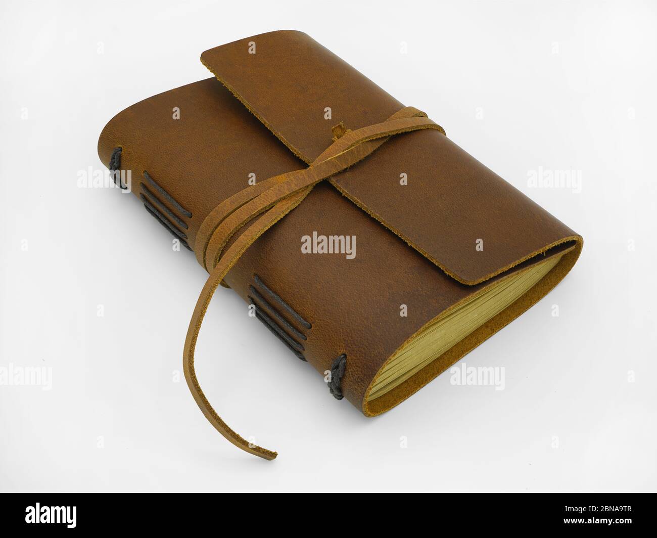 A closed brown eather-bound personal journal with leather strap and ...