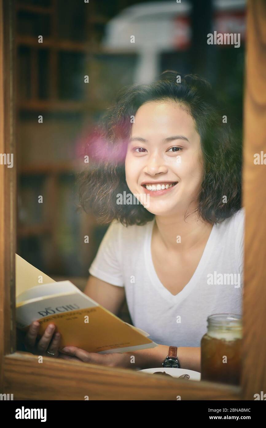 A girl is reading book with a smiling face Stock Photo - Alamy