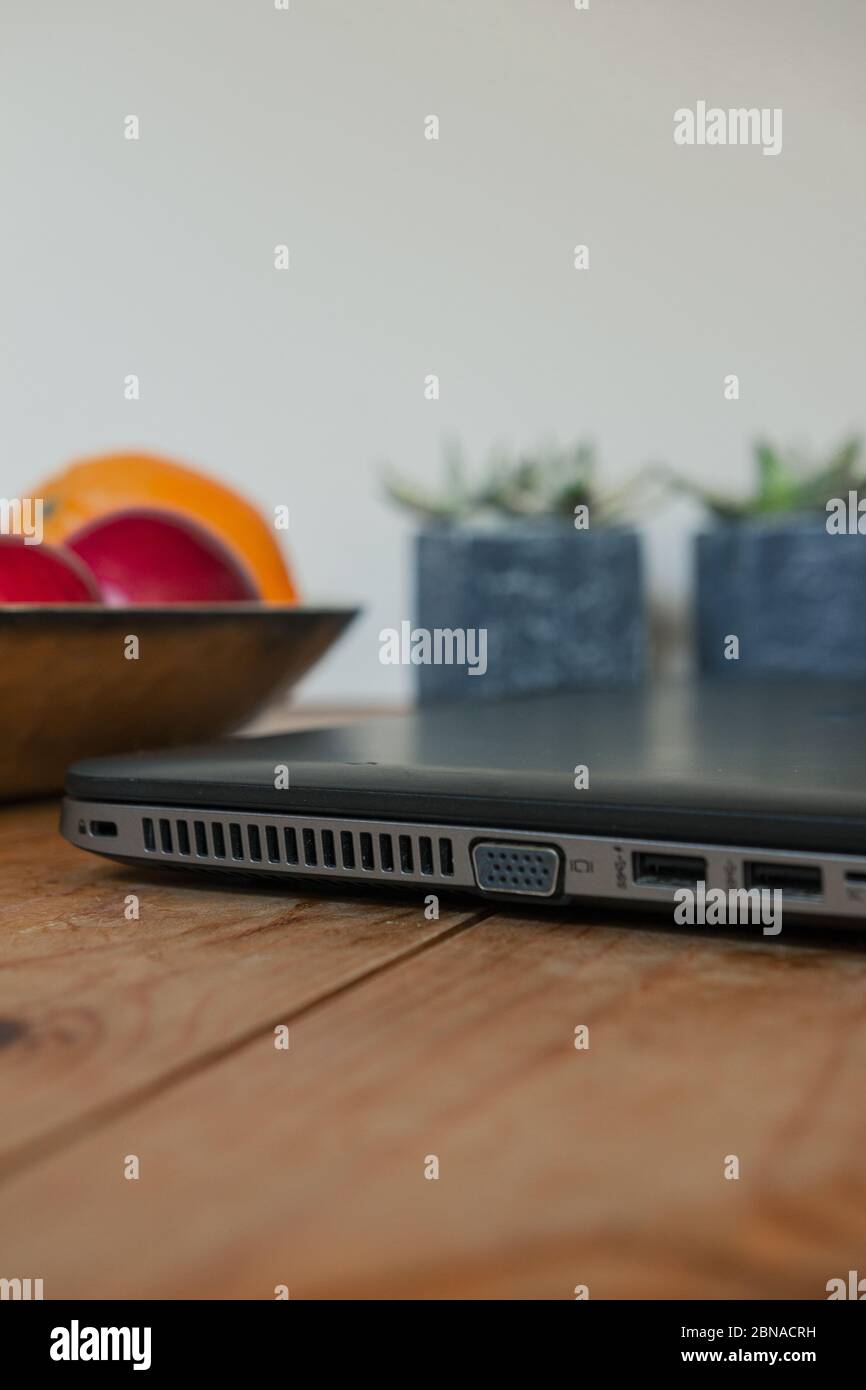 vertical shot of a notebook on a wooden table with a bowl of fruits and ...