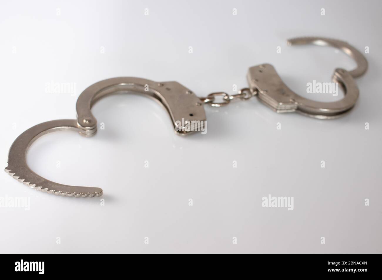 Closeup shot of a metal handcuffs on a white background Stock Photo - Alamy