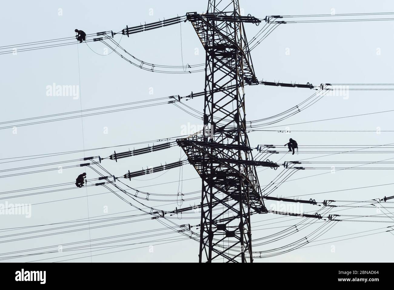High voltage engineers working on high voltage pylons hi-res stock ...