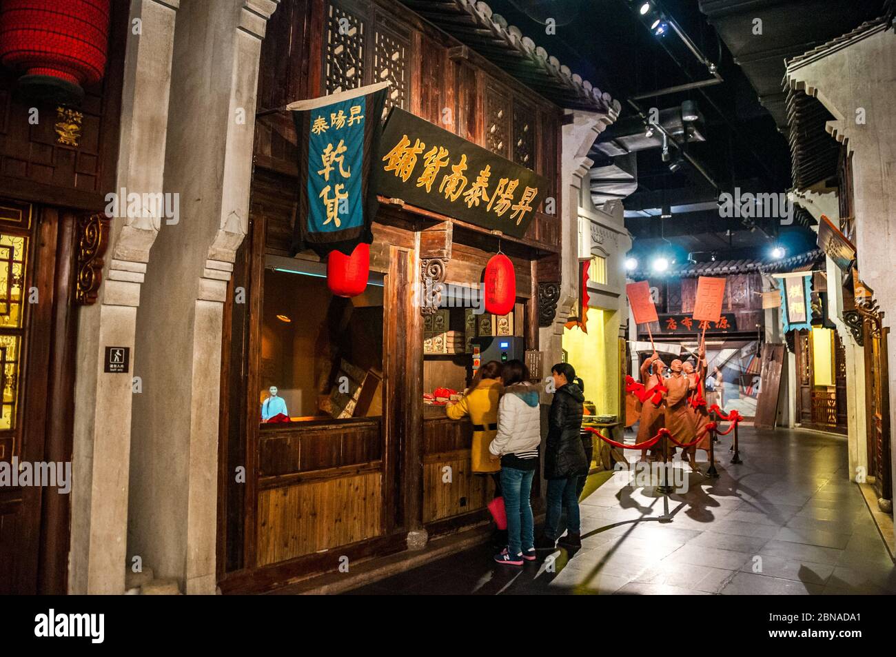 Three women look at a recreation of a traditional shop in the Ningbo ...