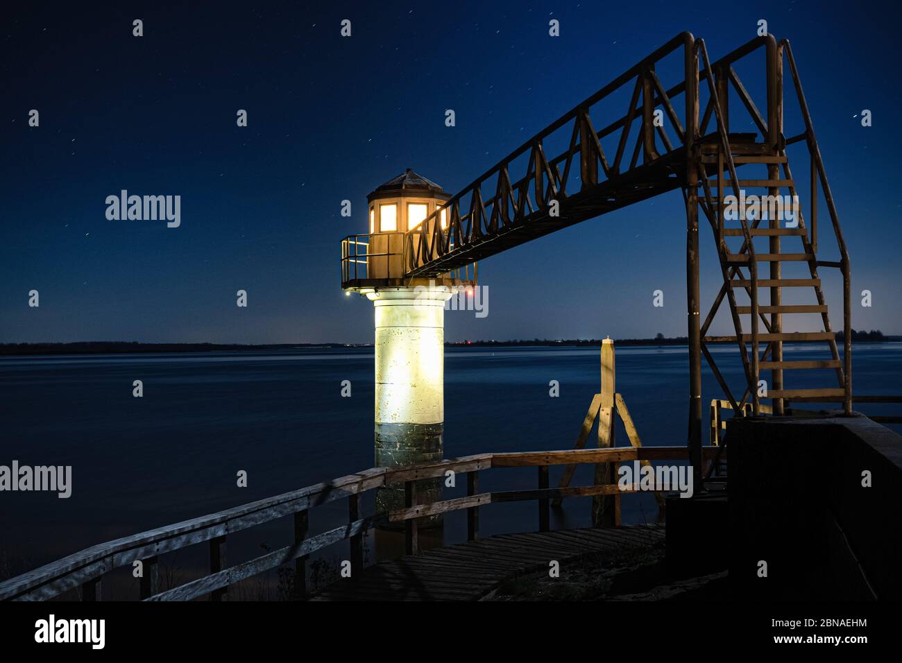 Tall lighthouse with a metal bridge on the seashore with a beautiful ...