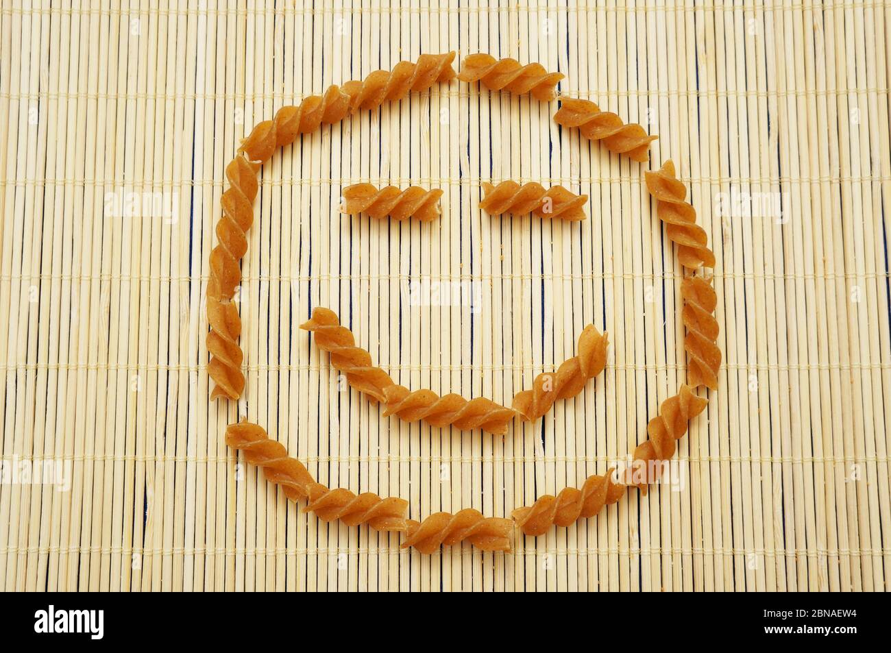 Overhead shot of a smiley face assembled from raw fusilli pasta Stock ...
