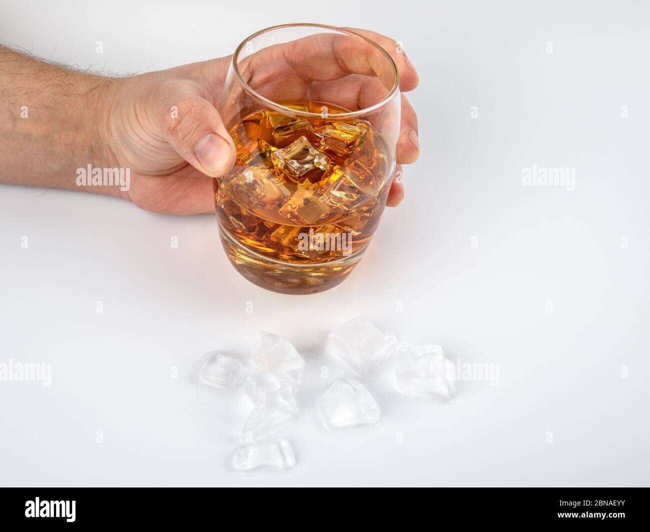 Glass of whisky and ice cubes on white background. Alcohol, addiction ...