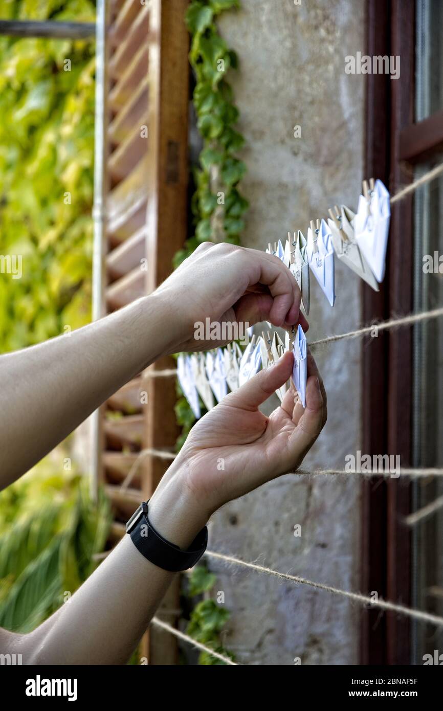 Vertical shot of a person hanging the table numbers with a name of ...