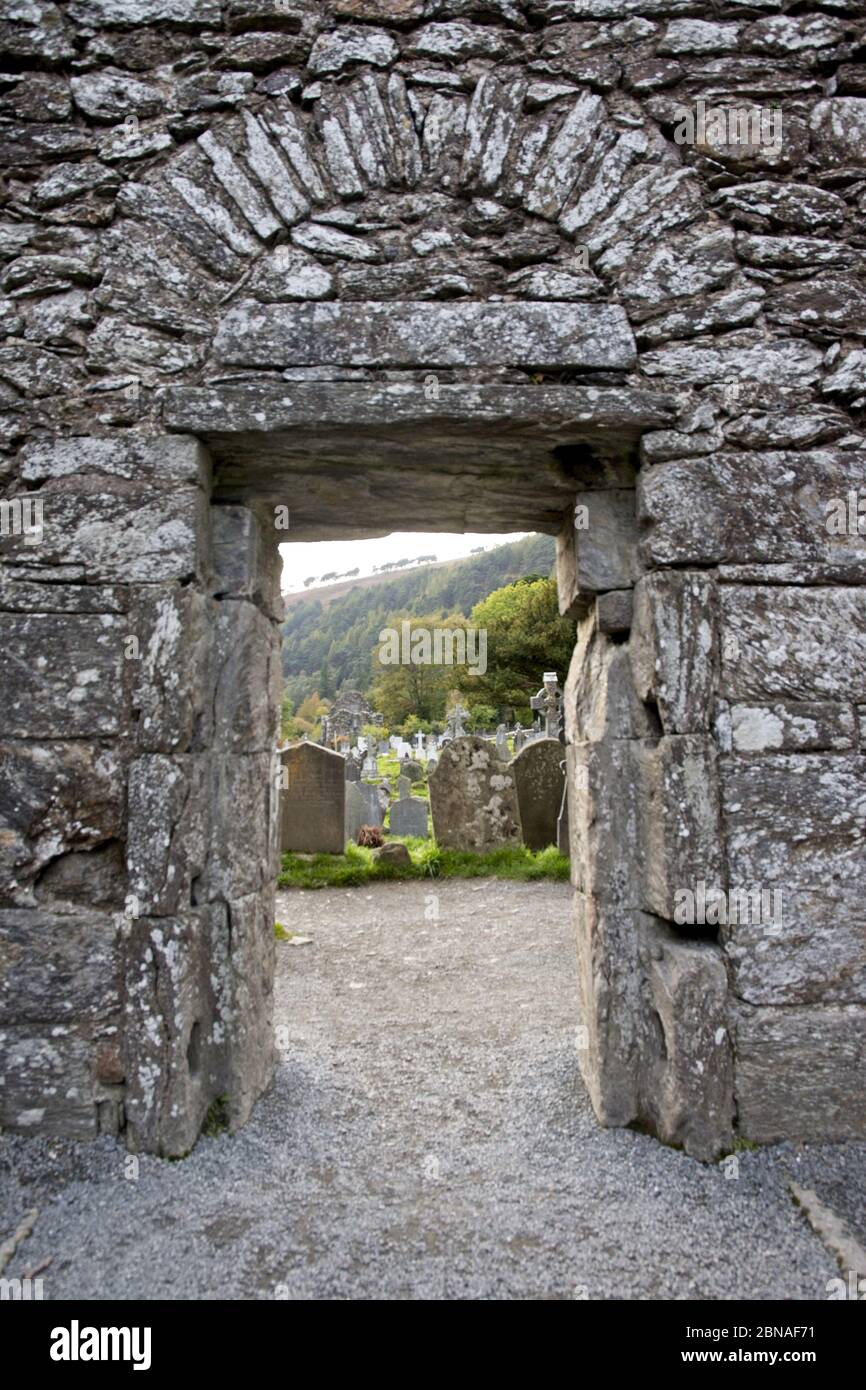 Closeup shot of a stone arch gateway with the cemetery in the ...