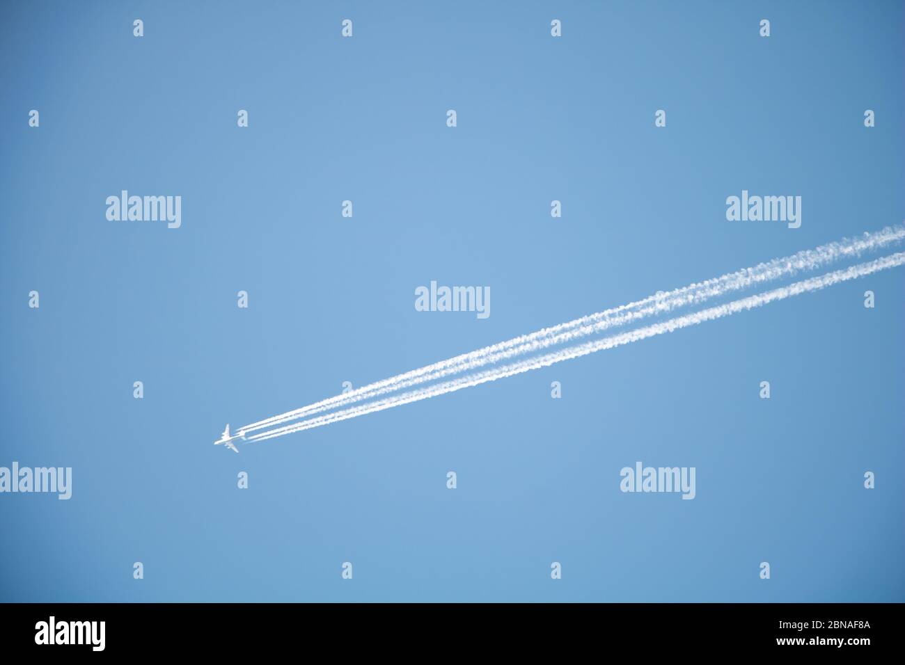 A plane is flying in the blue sky at high altitude. And leaves a white ...