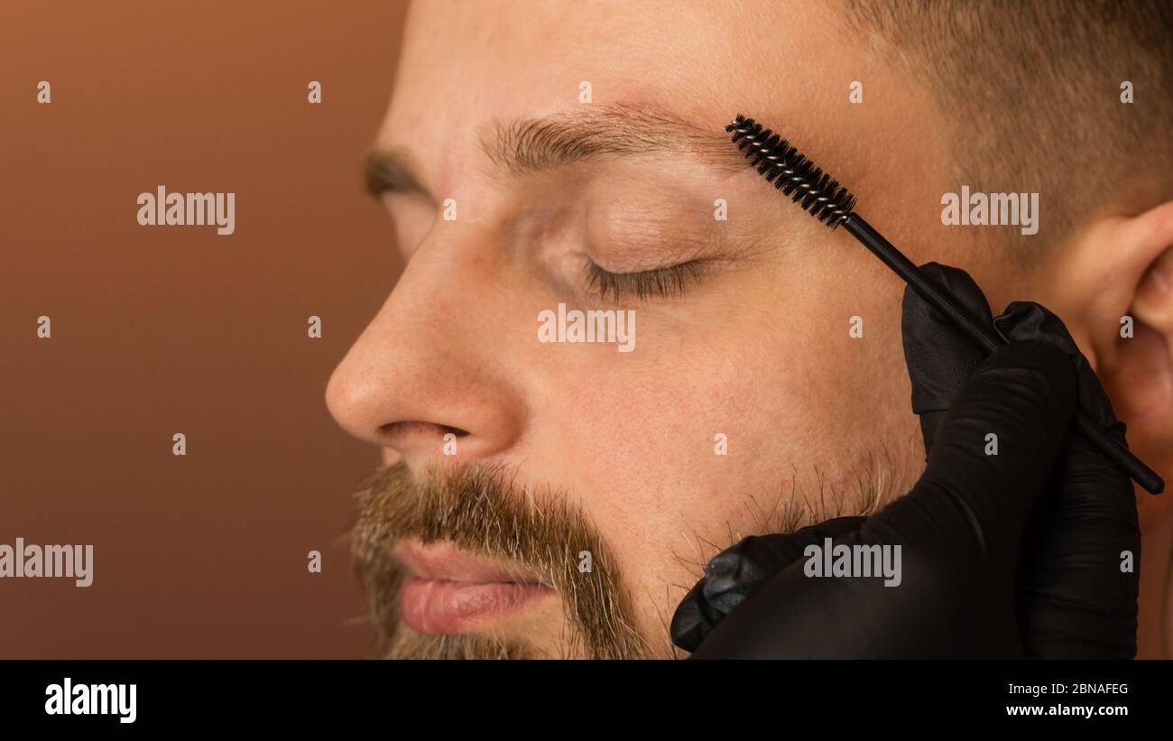 Correction shape of man eyebrow. Combing eyebrows and giving direction ...