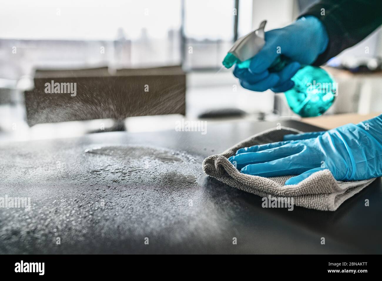 Sanitizing surfaces cleaning home kitchen table with disinfectant spray ...