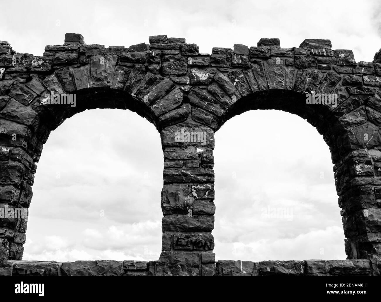 Low angle greyscale shot of the arch-shaped columns made of stone under ...