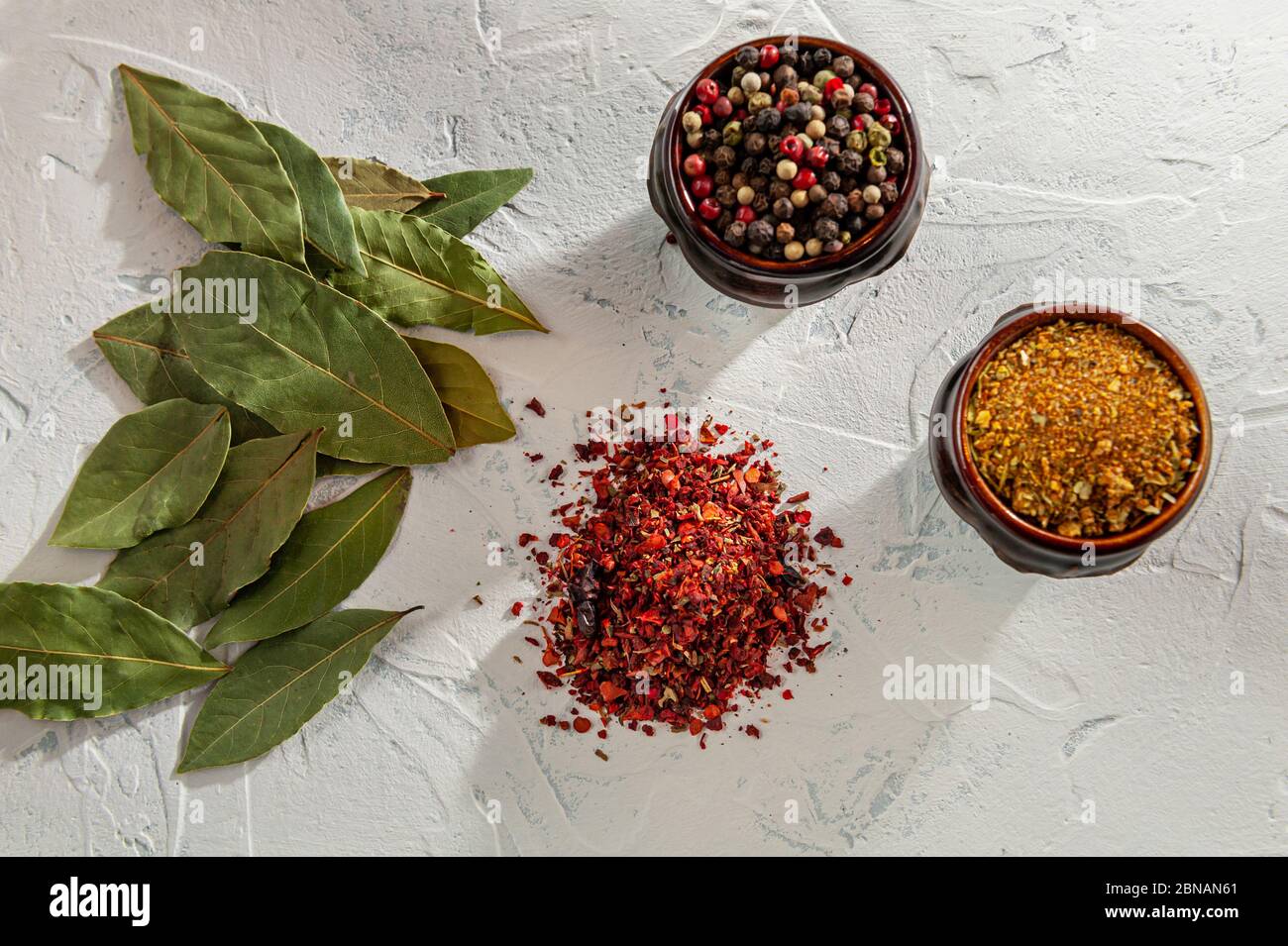 spices in cups are on the light background. Laurel pepper leaf and ...