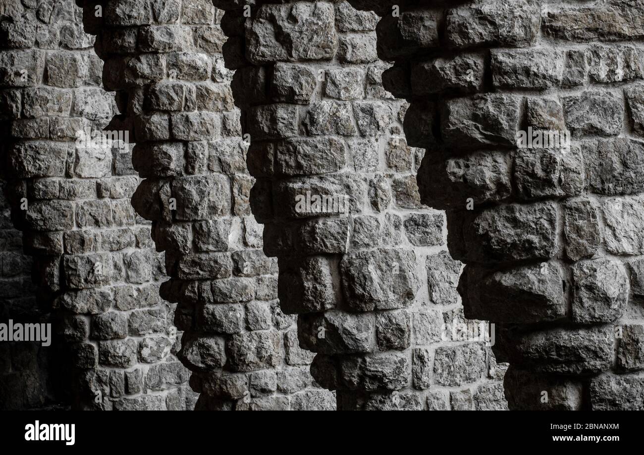 Greyscale shot of the brick columns of an old building captured during ...