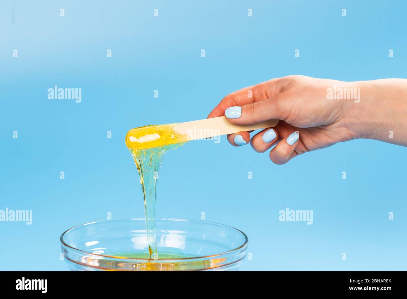 Yellow sugar paste for sugaring on a spatula close up on a blue ...