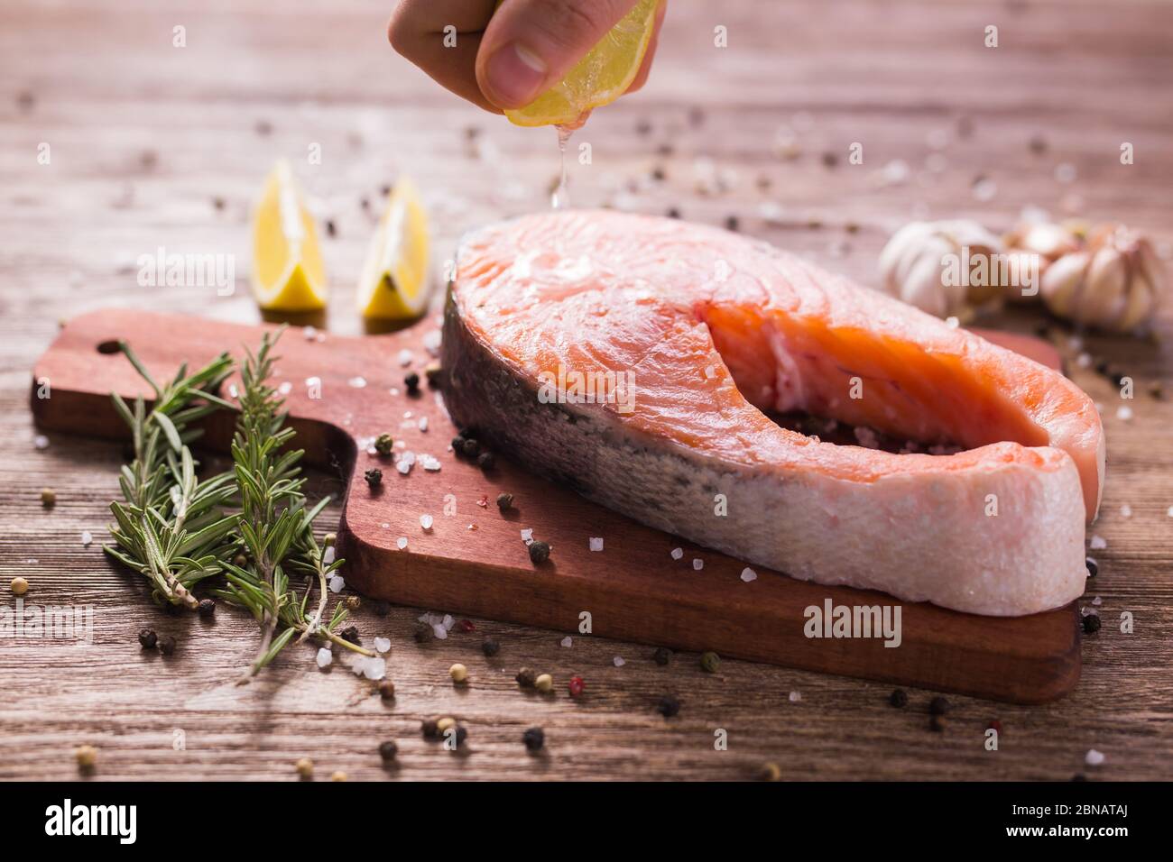 Squeezing fresh lemon juice on the fillets of fish. Cooking salmon ...