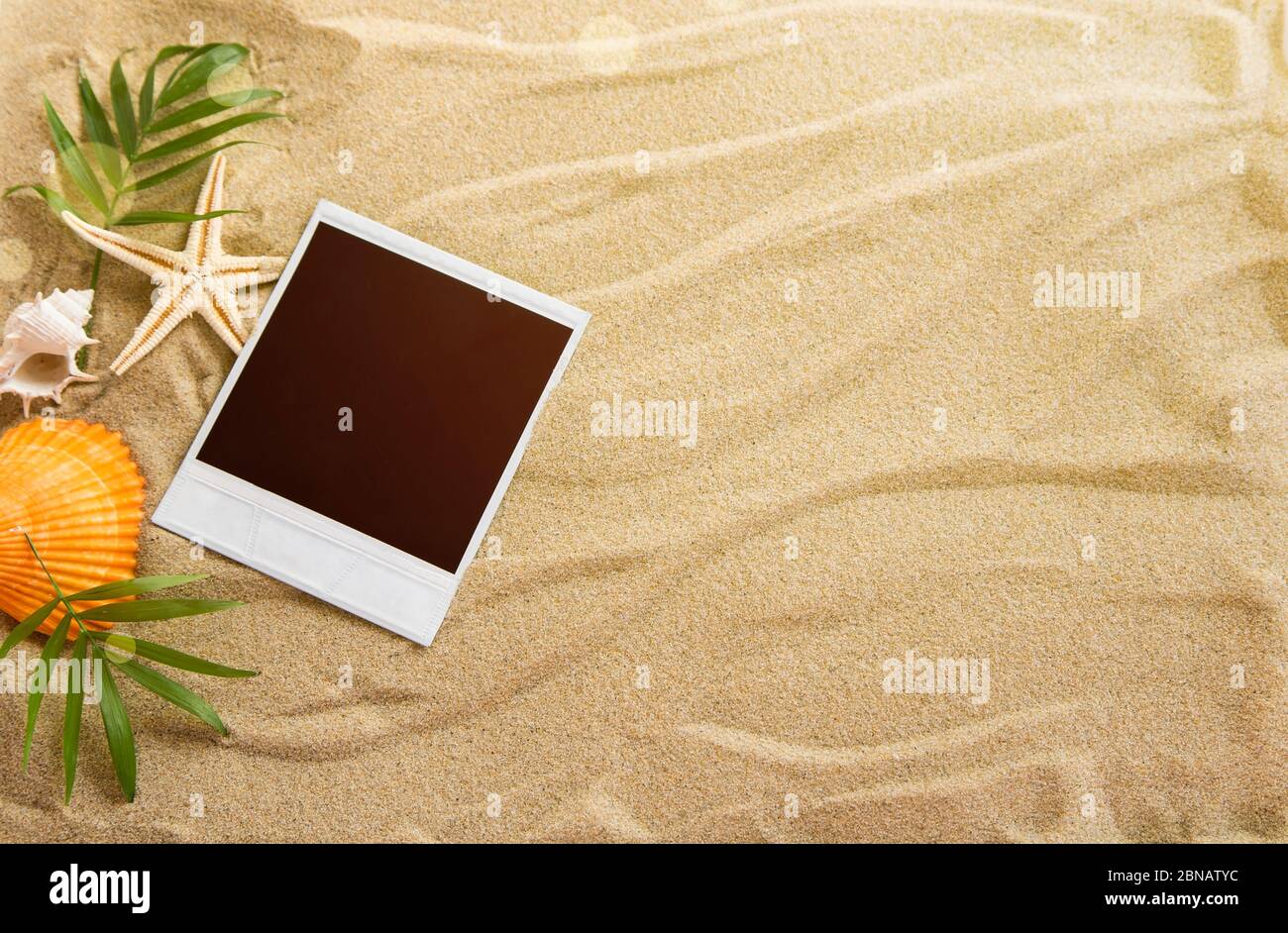 Summer background with a blank instant image on sand Stock Photo - Alamy