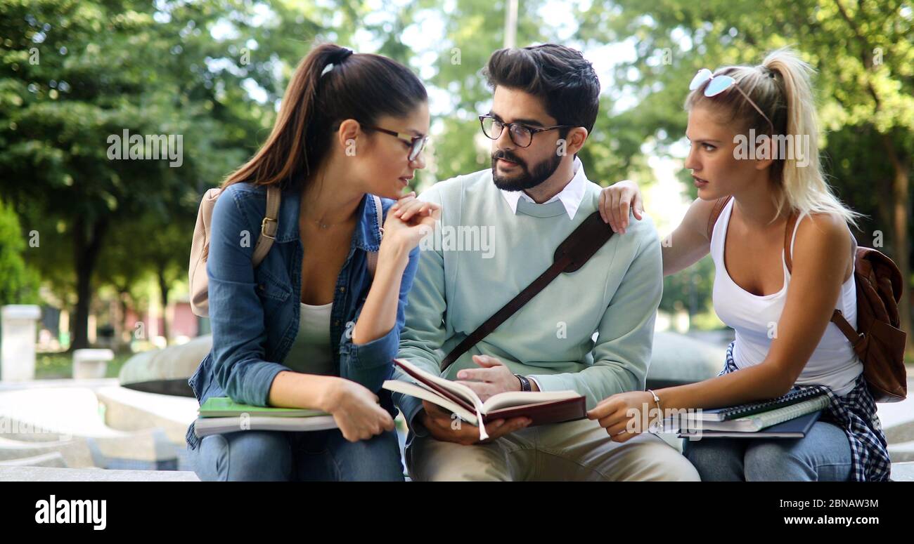 Happy young university students friends studying with books at ...