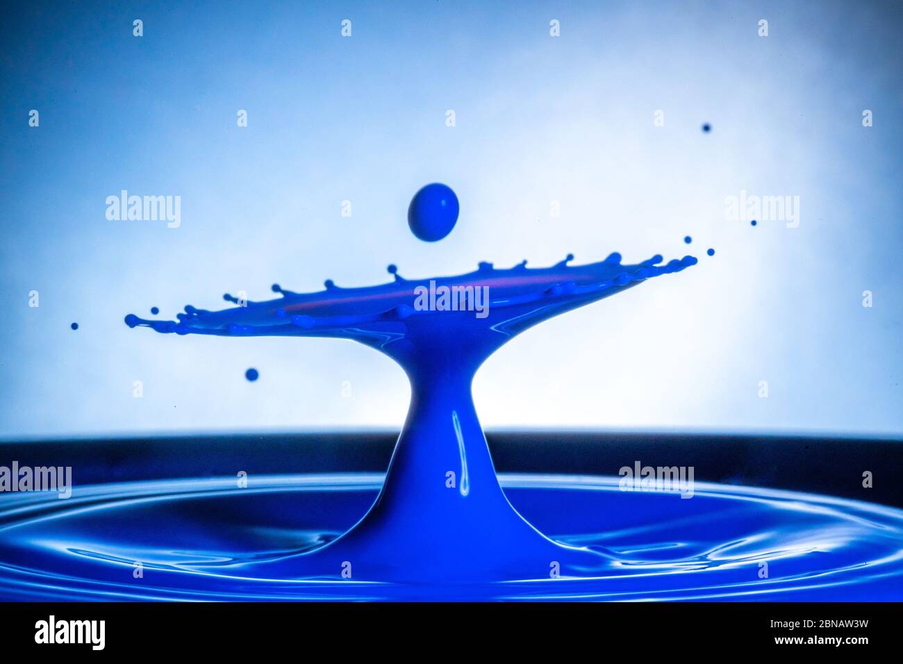 Closeup of a cool blue water splash against a blurred background ...