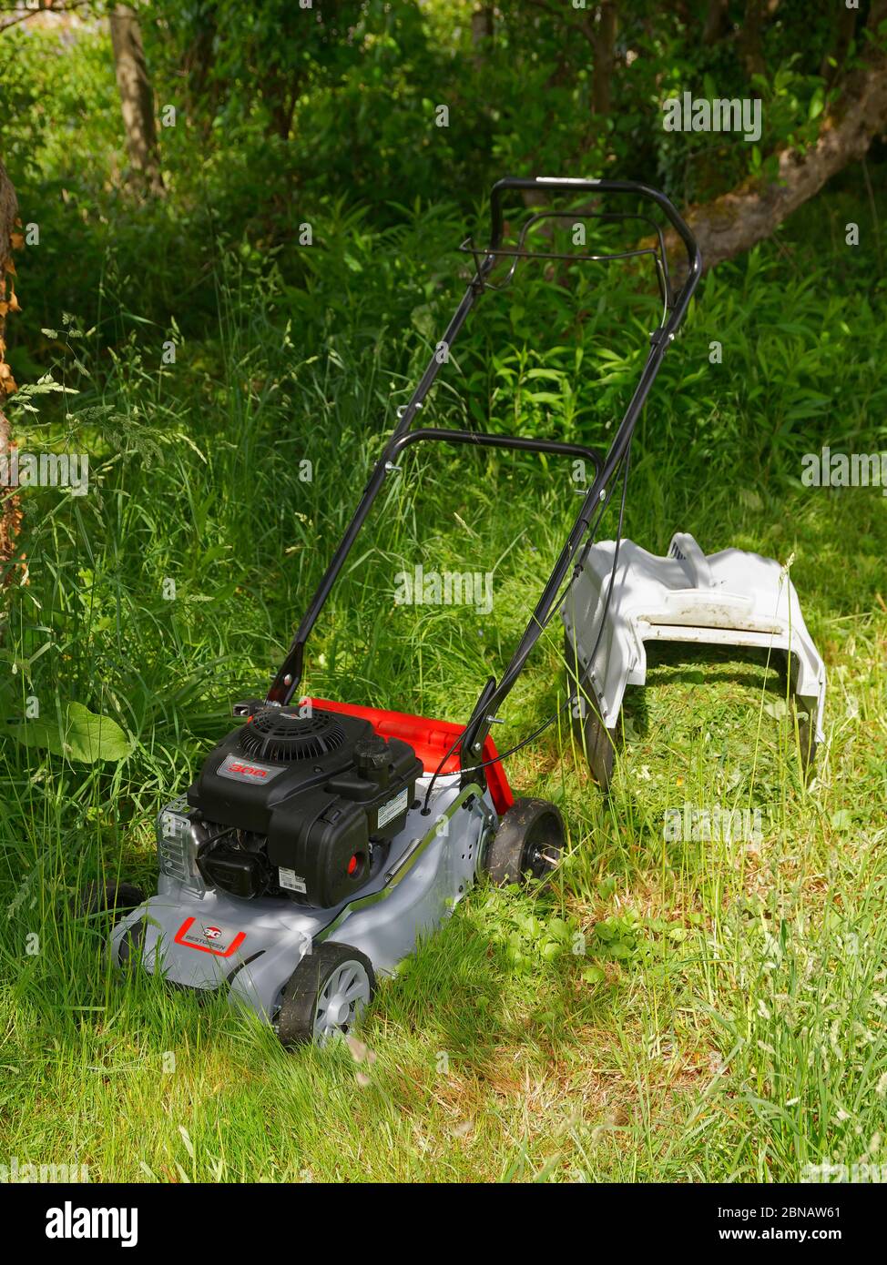 Lawn mower in a garden path Stock Photo - Alamy
