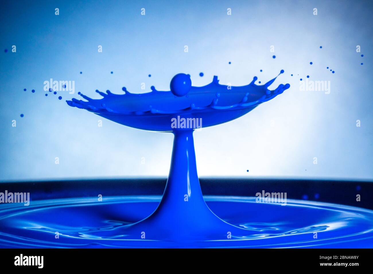 Closeup of a cool blue water splash against a blurred background ...