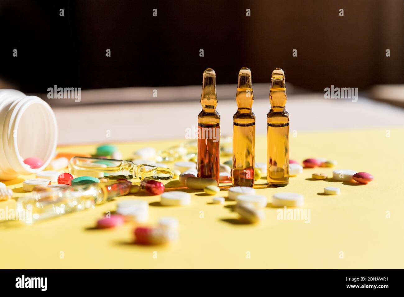 medical ampules, bottle, pills isolated on yellow background.Selective ...