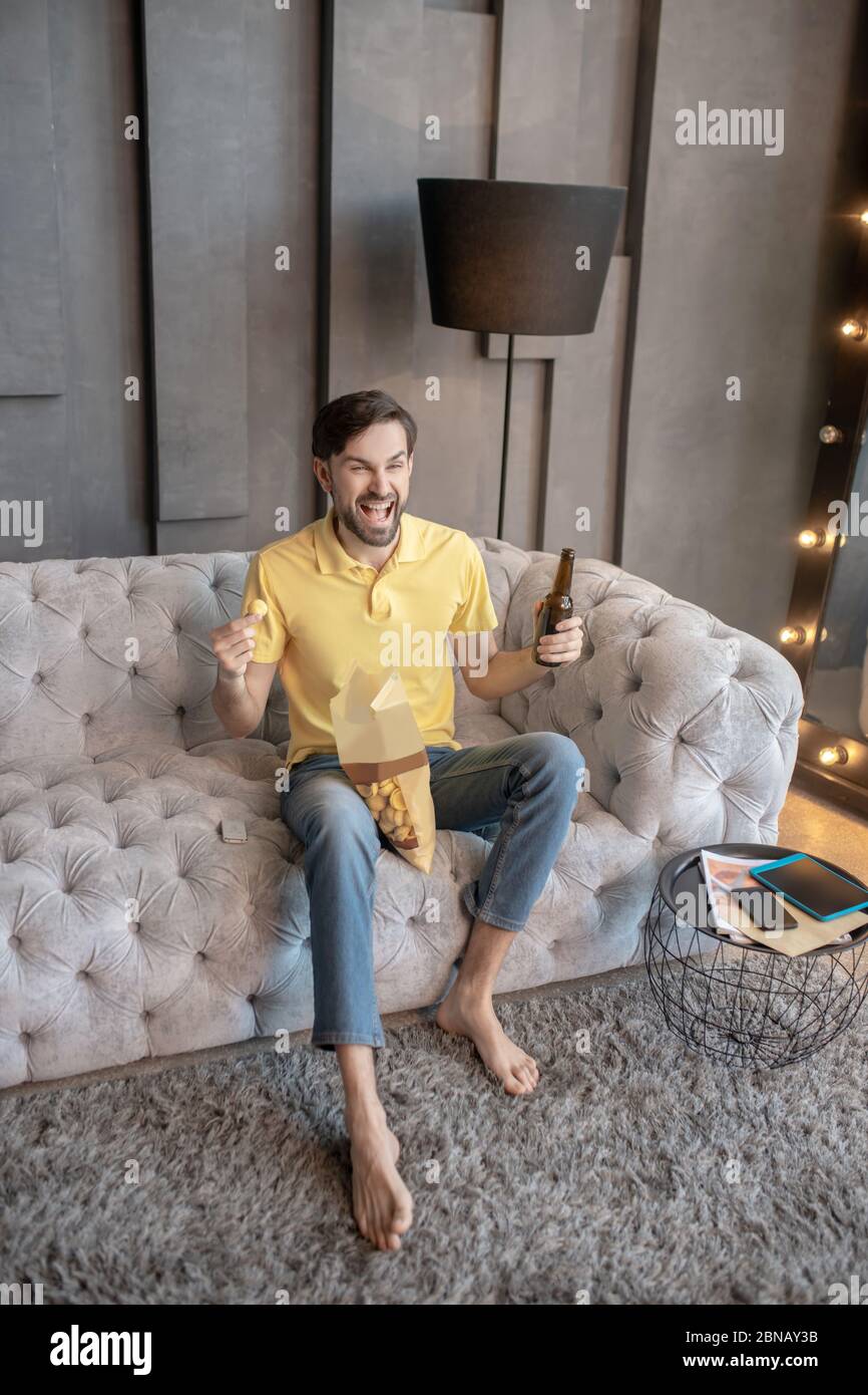 Enthusiastic laughing man with beer and chips Stock Photo - Alamy