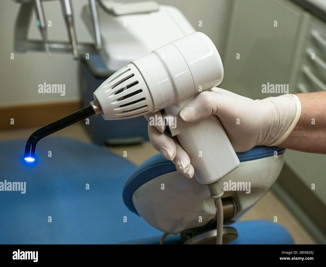 Dentist holding a piece of dental equipment inside a dentist's office ...