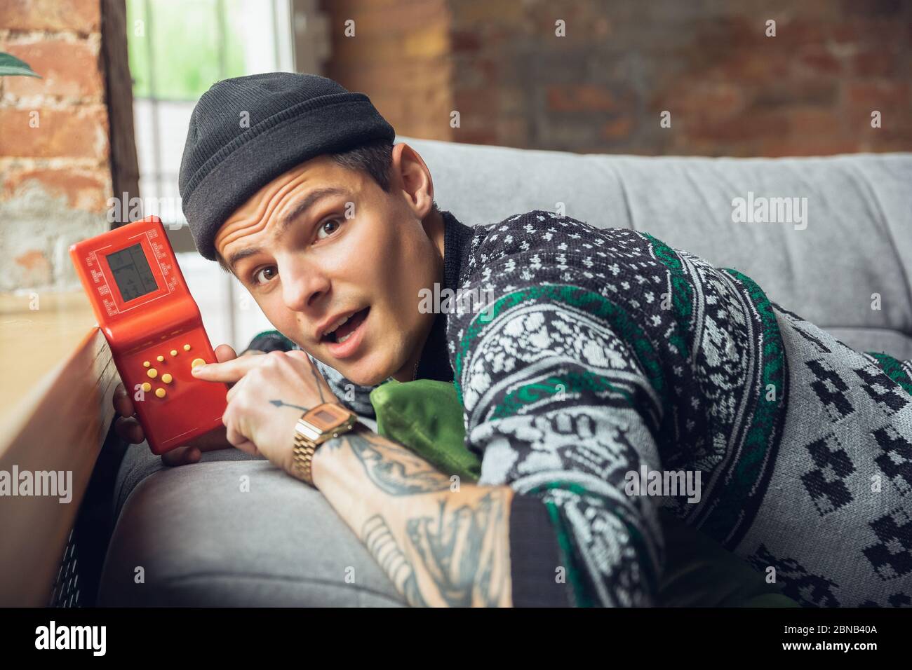 Portrait of millenial boy using retro toys, meeting things from the ...