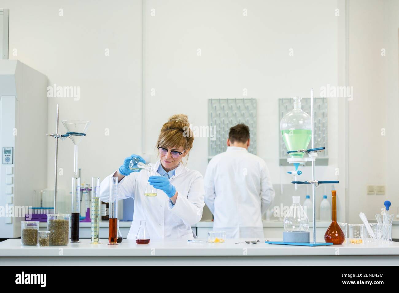 Female chemical scientist wearing glasses works with hemp CBD and CBDa ...