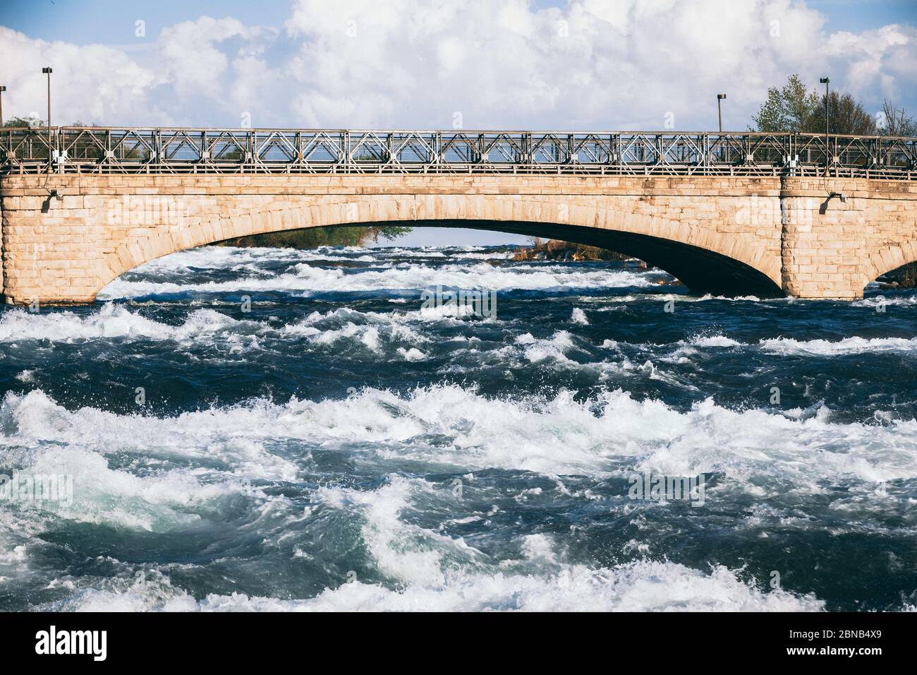 Stone bridge over splashing water during daytime Stock Photo - Alamy
