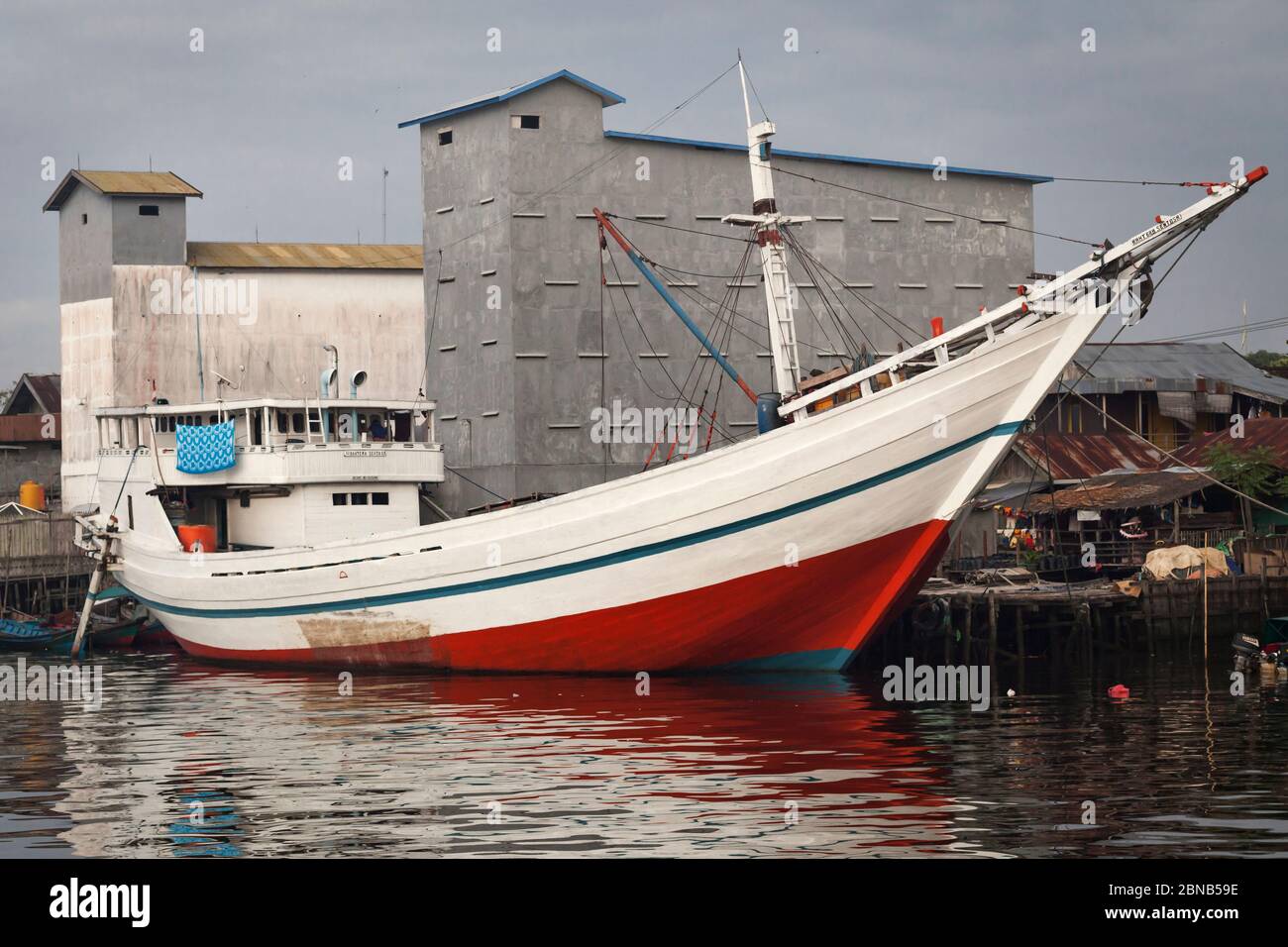 Horizontal view of a wooden red and white ship moored in the port in ...