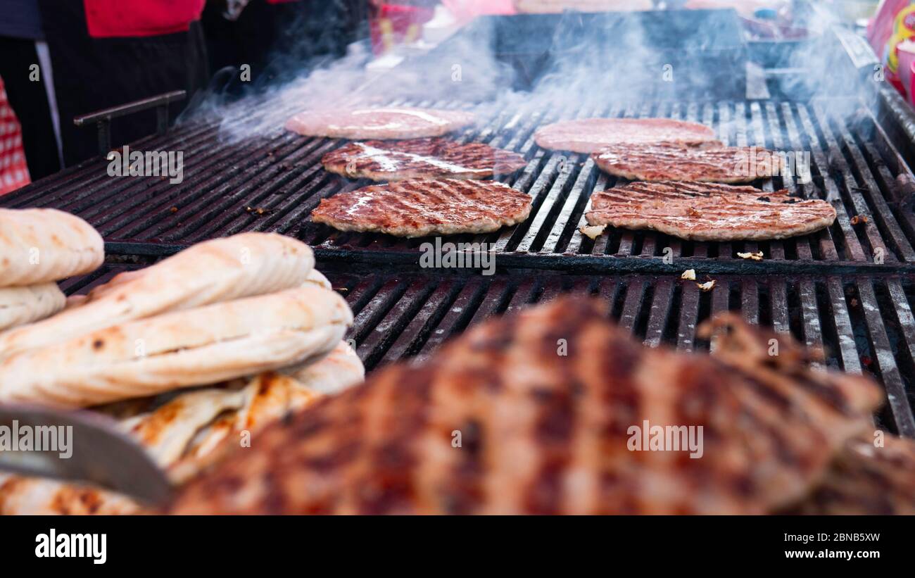 Burgers and buns on the grill Stock Photo - Alamy