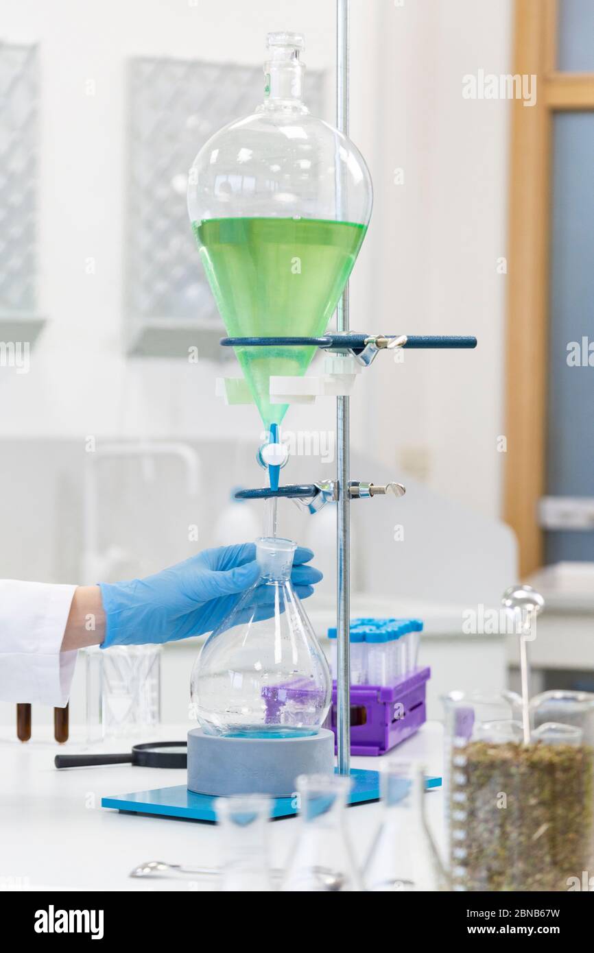 Close up shot of hand wearing rubber gloves work with blue liquid in ...